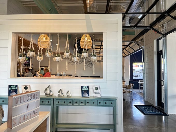 The entrance welcomes you with coastal charm and macramé plant hangers that somehow avoid being kitschy – a design feat worthy of HGTV.