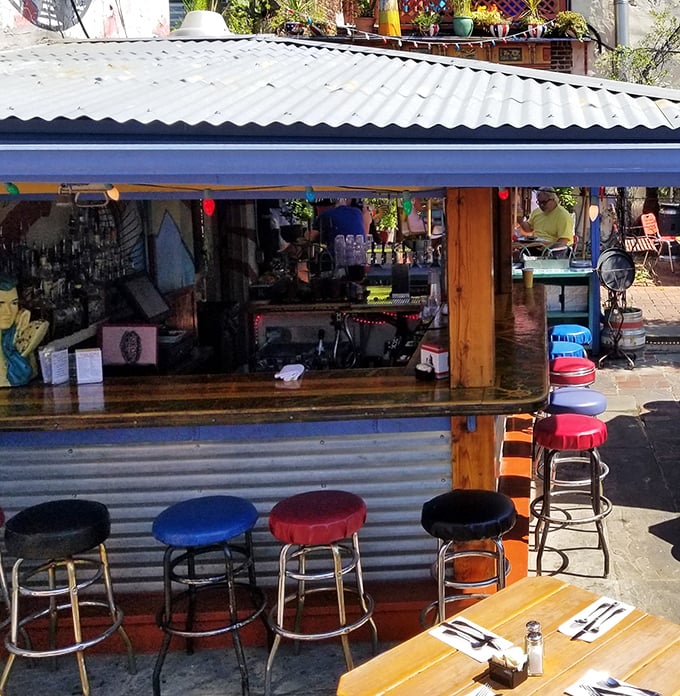 The outdoor bar area offers colorful stools and casual vibes—the kind of spot where one drink easily turns into an afternoon of people-watching.