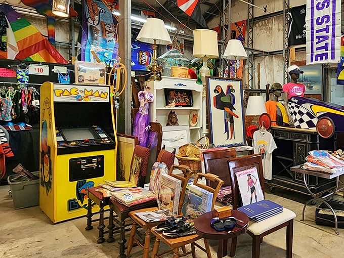 The iconic yellow Pac-Man arcade cabinet stands among vintage furniture—a pixelated portal to countless quarters spent in 1980s arcades.
