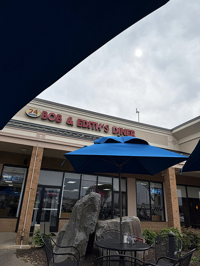 Even under moody skies, Bob & Edith's blue umbrellas offer a promise: good food awaits, rain or shine, day or night.