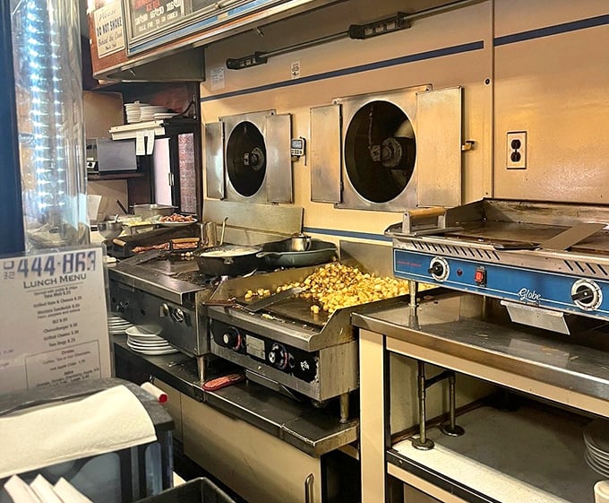 The beating heart of the diner—a compact kitchen where home fries sizzle on the flattop and breakfast dreams become reality.