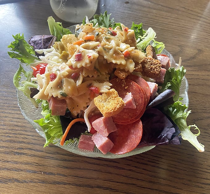 Fresh greens topped with pasta salad, meats, and all the fixings—this isn't a side salad, it's a full production.