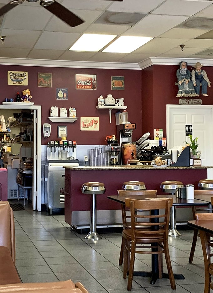 Vintage signs and whimsical teapots adorn burgundy walls – not because a designer said so, but because someone actually loves these things.