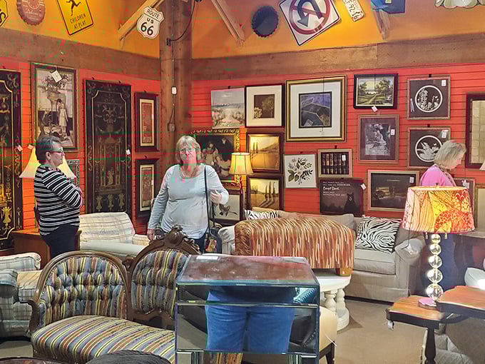 The thrill of the hunt captured – shoppers navigate a sea of furniture and framed art in this colorful treasure-filled corner.