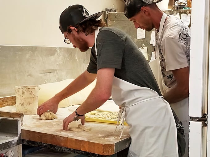 Artisans at work, their hands moving with practiced precision, crafting each donut as if it were destined for a museum instead of your mouth.