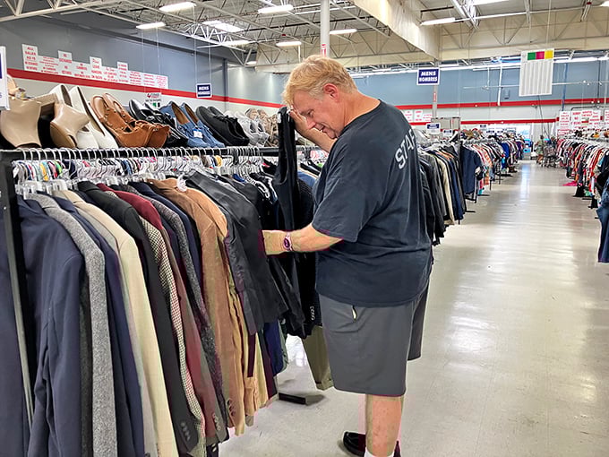The thrill of the hunt captured in real-time. This shopper examines each garment with the careful consideration of a diamond appraiser—because sometimes, that's exactly what he is.