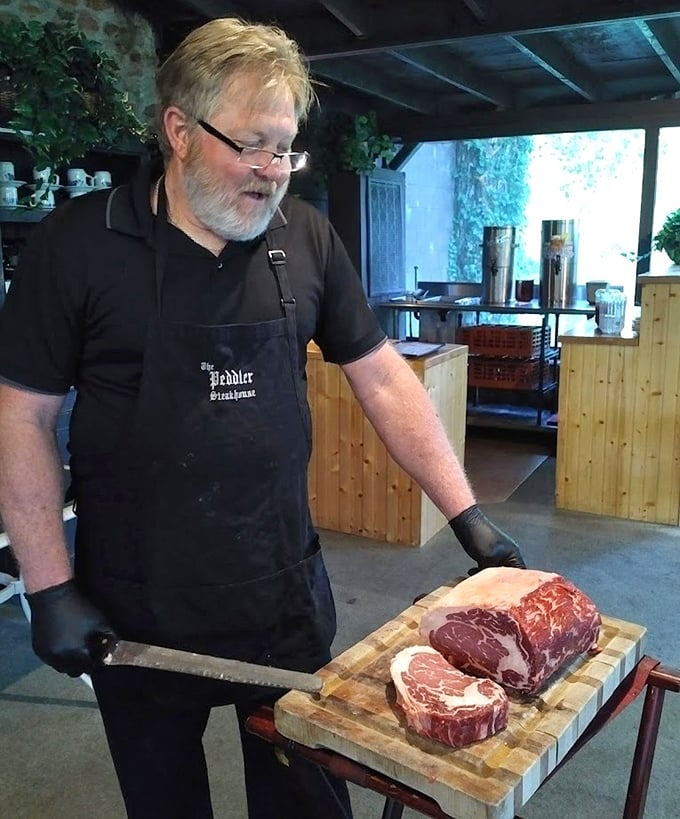 The meat cutter's skilled hands tell a story of tradition and craft—this isn't just steak preparation, it's performance art.