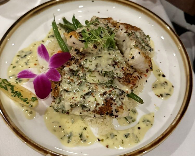 This tile fish special rests on a bed of savory goodness. The vibrant orchid and lime wedge add both color and zesty possibility.