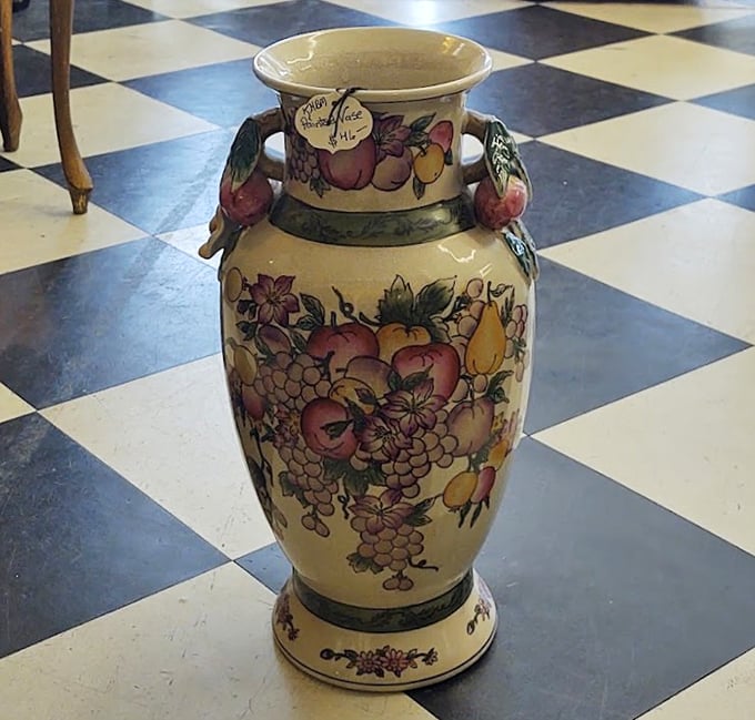 This fruit-adorned ceramic vase stands proudly on the checkerboard floor, a testament to an era when "Made in Italy" meant handcrafted, not mass-produced. 