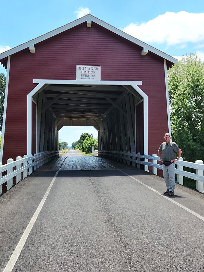 The scale of the bridge becomes apparent when humans stand beside it. This isn't just a crossing—it's a wooden cathedral dedicated to the art of travel.