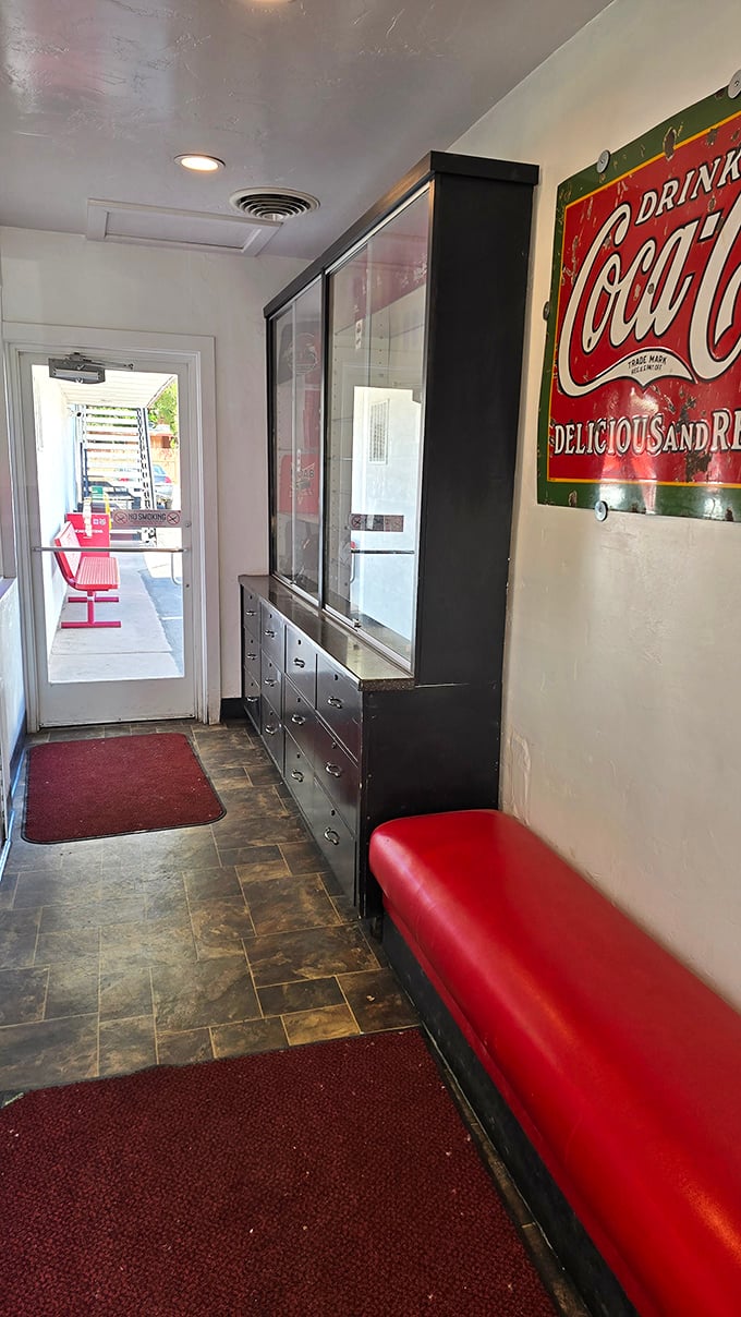 Even the waiting area tells a story—vintage Coca-Cola signs, red vinyl seating, and the anticipation of comfort food just steps away.
