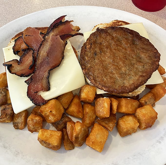 A proper diner burger doesn't need truffle aioli or artisanal buns—just quality beef, melty cheese, crispy bacon, and those golden home fries.