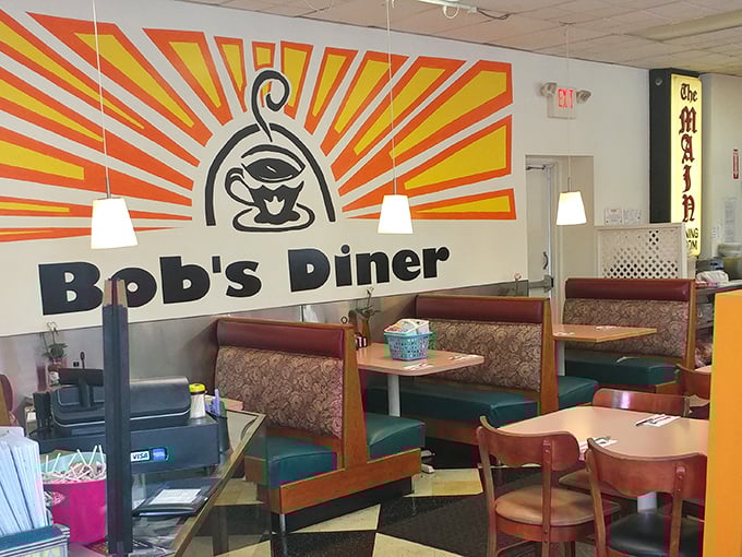 The iconic sunburst logo watches over diners like a breakfast deity—promising that in this booth, all hunger shall be vanquished. 