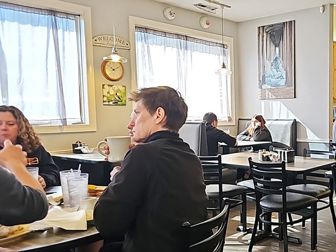 Bright windows flood the dining area with natural light. The "Welcome" sign isn't necessary—the atmosphere already said it.