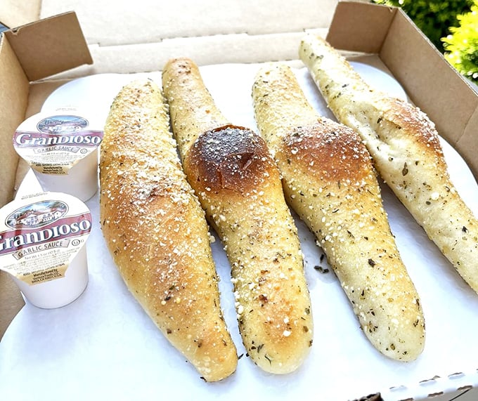 These breadsticks aren't just appetizers, they're a preview of coming attractions – golden, herb-flecked wands of pure carb magic.