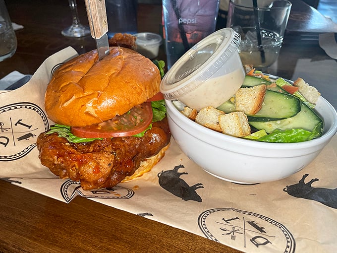 This chicken sandwich means business—crispy, saucy, and served with a side salad for those pretending to make healthy choices.