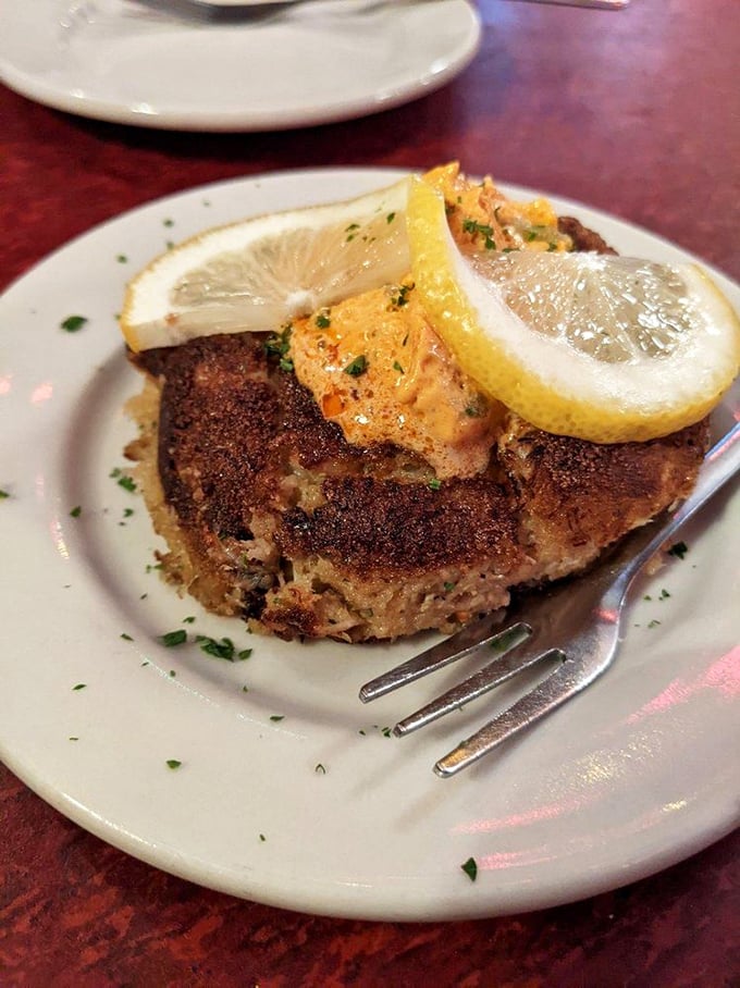 This crab cake isn't just seafood—it's a golden-crusted island of flavor topped with a bright citrus accent that makes your taste buds stand at attention.