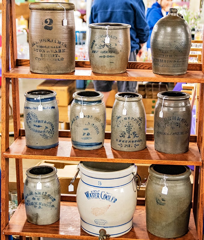 These stoneware crocks once preserved the harvest – now they preserve history with their hand-painted blue markings and sturdy presence.