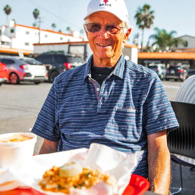 A satisfied diner enjoys his meal al fresco. That expression says, "I've found seafood nirvana, and I'm never leaving this chair."