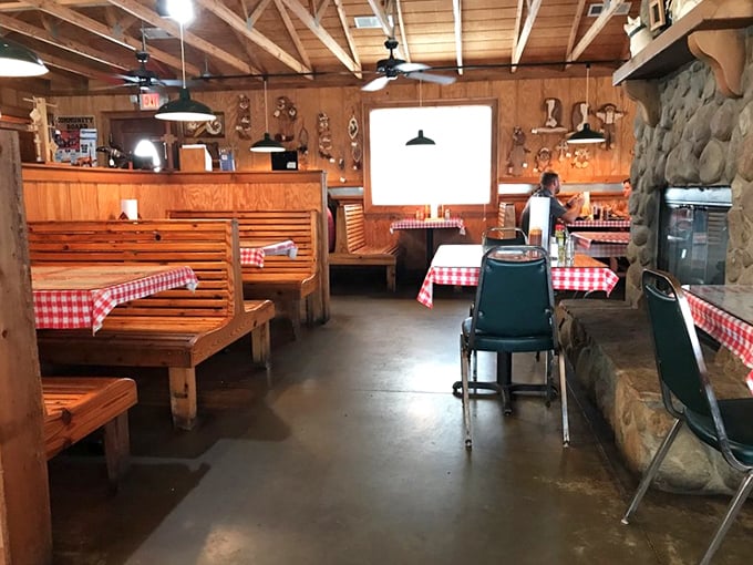 Wooden booths with red-checkered tablecloths – the universal signal that you're about to eat something honest, unpretentious, and deeply satisfying.