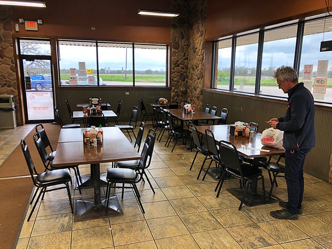 Morning light streams through windows as a lone diner enjoys the quiet ritual of coffee and kolache – a moment of zen on Highway 71.