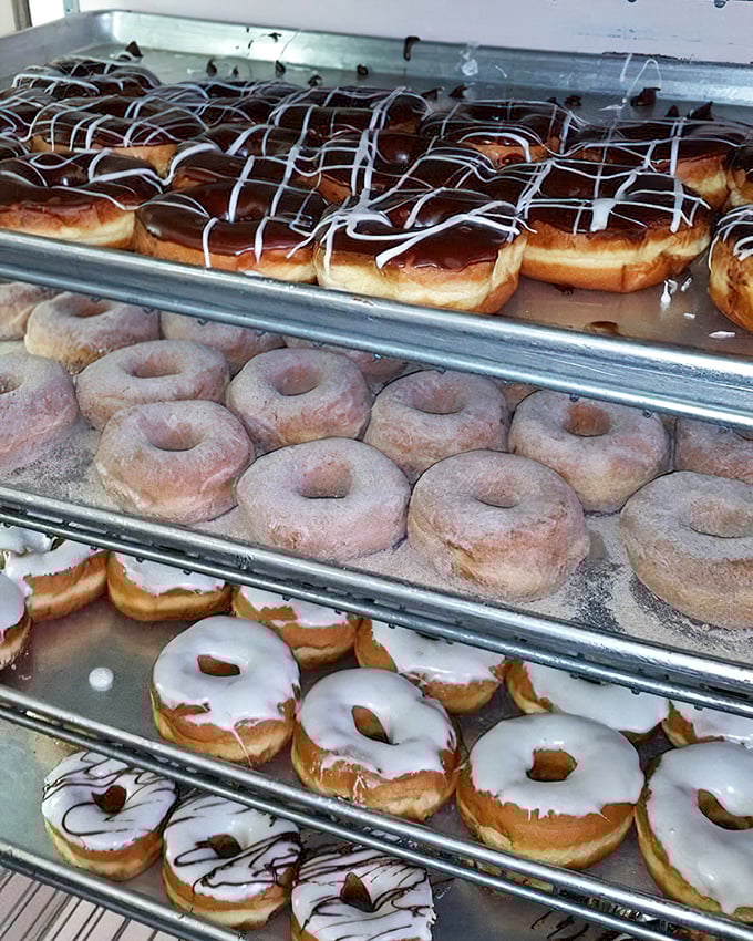 Donut nirvana—glazed, powdered, and chocolate-drizzled circles of joy stacked with the precision of a Swiss watchmaker.