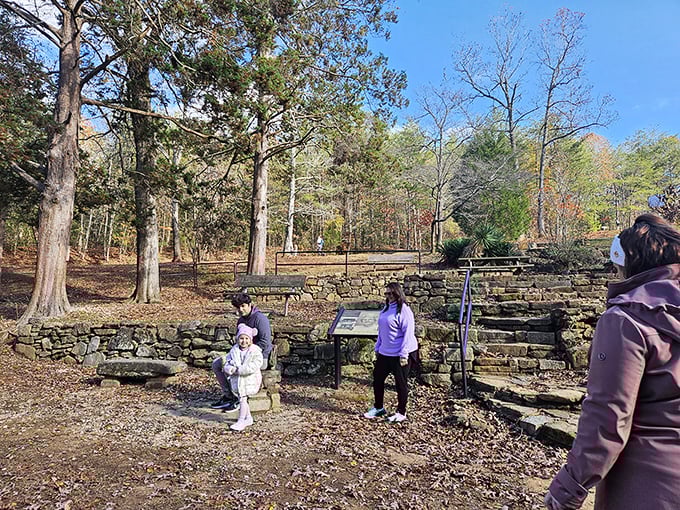 The remnants of the old mill foundation offer a glimpse into the bridge's practical origins as part of a bustling rural community.