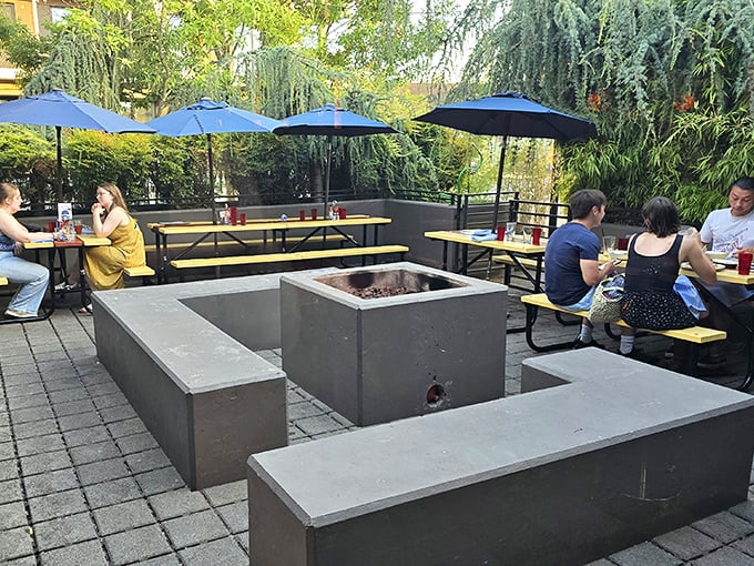 The concrete fire pit doesn't just warm hands—it extends Portland's precious outdoor dining season well into the months when umbrellas usually hibernate.
