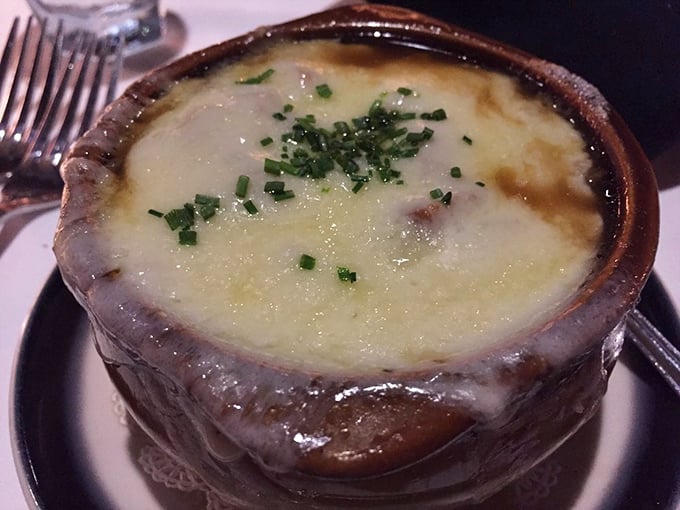 The legendary French onion soup in its natural habitat – a ceramic crock of bubbling, cheesy perfection that's worth every calorie.