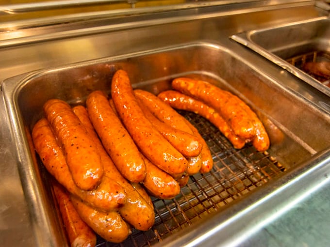 Sausages glistening with promise in their hot bath—the unsung heroes of any respectable barbecue spread.