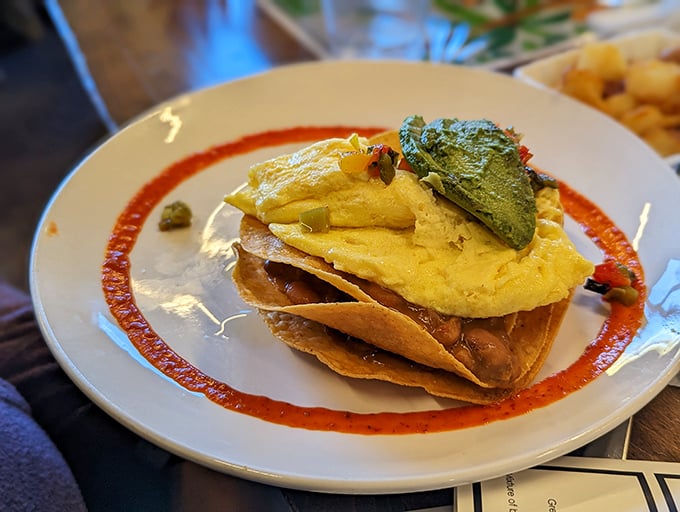 These huevos rancheros aren't just stacked—they're architecturally sound breakfast towers with layers of flavor that would make Frank Lloyd Wright jealous.