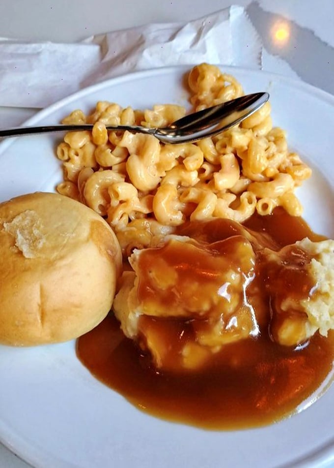 Mac and cheese that would make your childhood self weep with joy, alongside mashed potatoes swimming in gravy's warm embrace.