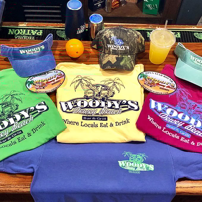 Woody's merch proudly proclaims "Where Locals Eat & Drink"—the ultimate endorsement in any beach town worth its salt water.