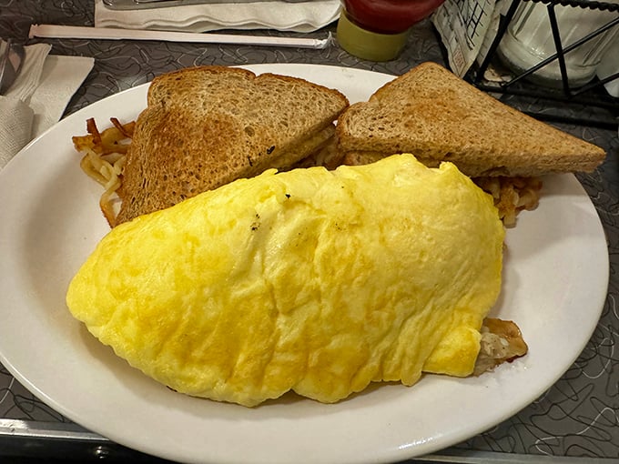 The omelet that ate Manhattan – fluffy, golden, and large enough to feed a small family, with perfectly toasted bread standing guard.