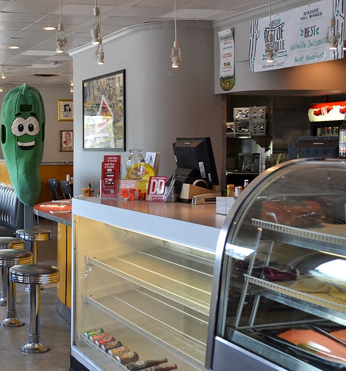 The pickle mascot standing guard by the counter is both whimsical and appropriate—a crunchy sentinel watching over the deli kingdom.
