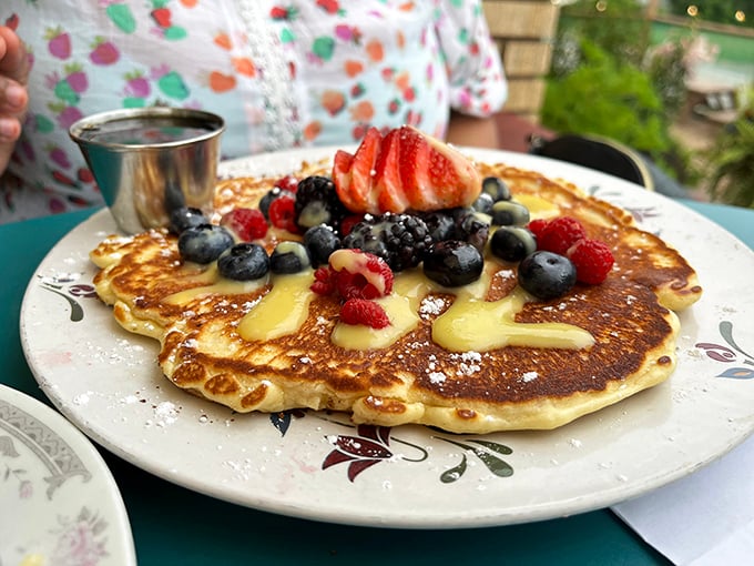 A pancake that deserves its own Instagram account—golden, fluffy, and adorned with berries that pop like nature's candy.