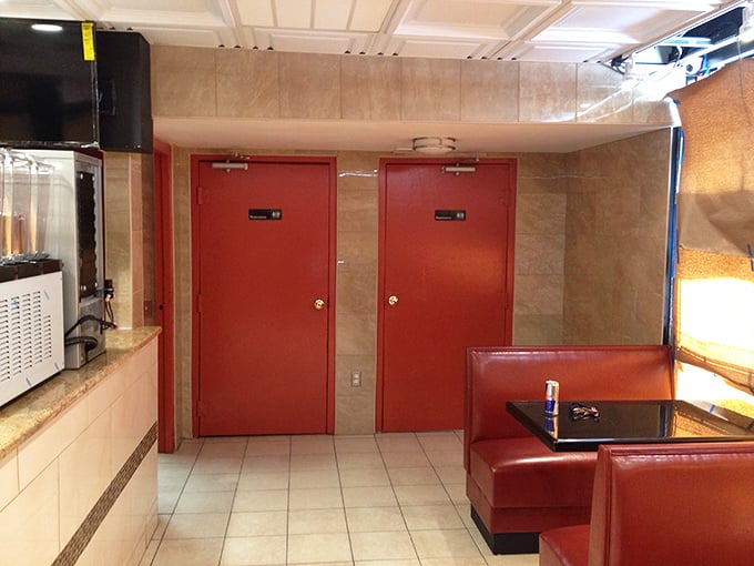 The restroom doors stand like crimson sentinels, maintaining the restaurant's signature color palette even in the most utilitarian spaces.