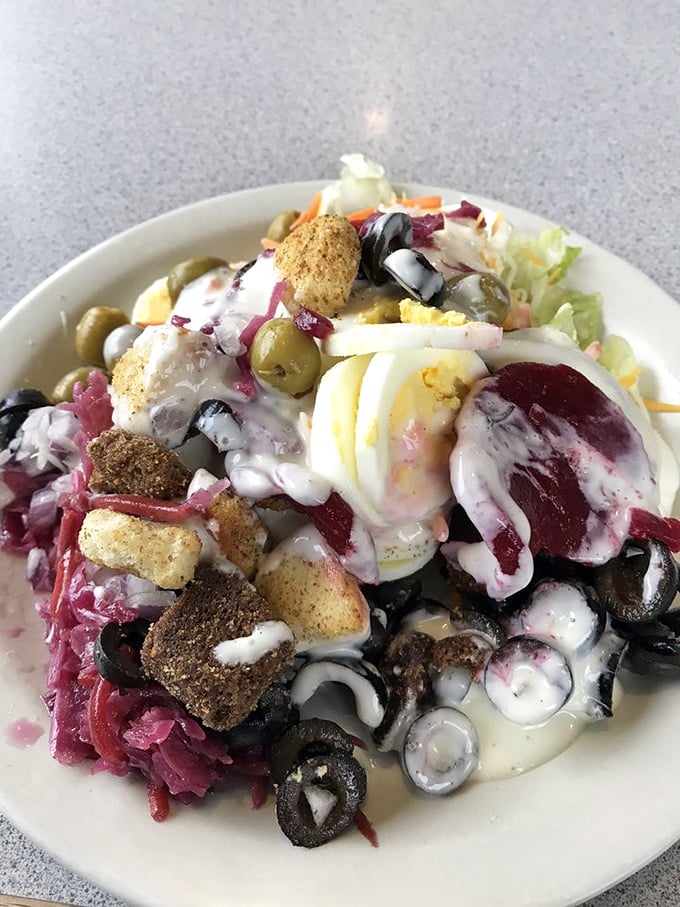 This isn't just a salad—it's a colorful neighborhood where olives, eggs, and croutons live in perfect harmony under a creamy sky.