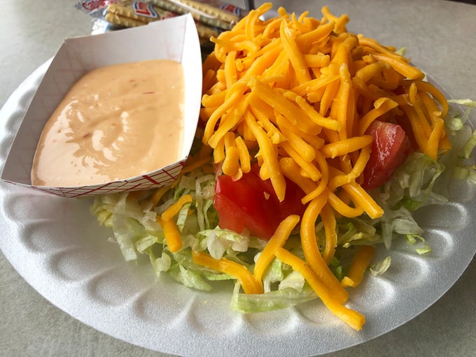 A simple side salad topped with shredded cheddar—because sometimes you need something green before diving into burger paradise.