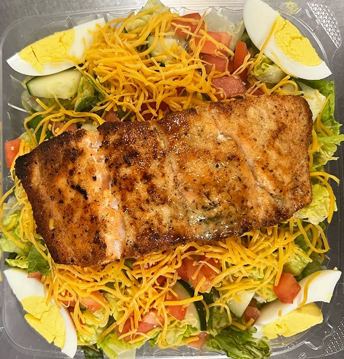 A perfectly seasoned salmon fillet resting on a bed of fresh salad—because sometimes even soul food lovers need a lighter option (that's still heavy on flavor).