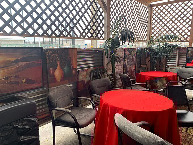 Red tablecloths pop against gray chairs in the covered patio area—a casual setting for serious eating where conversations flow as freely as the sweet tea.