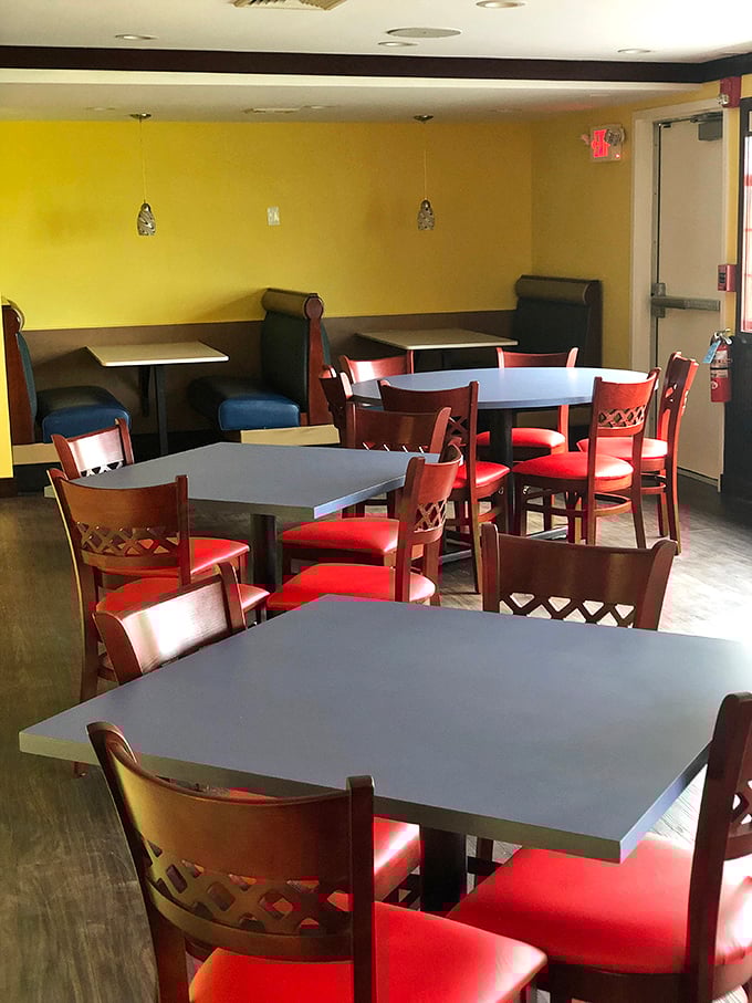 Cheerful yellow walls and cherry-red chairs create a dining room that feels like happiness decided to open a restaurant.