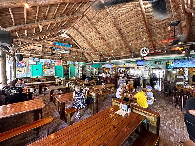 Wooden picnic tables under a thatched roof—where conversations between strangers turn into friendships and seafood turns into memories.