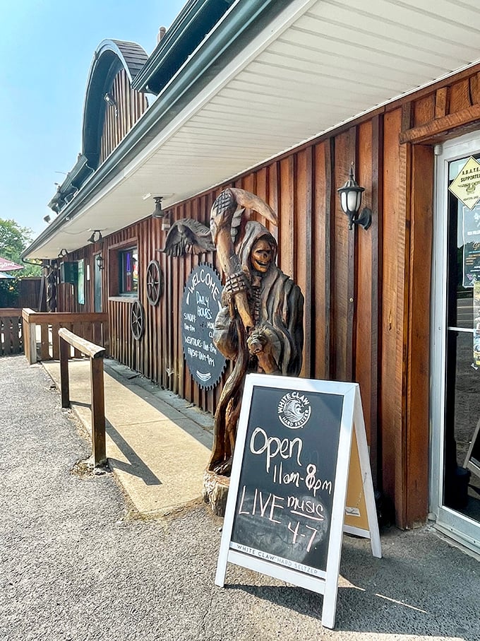 A wooden sentinel guards the entrance, while a chalkboard promises live music—because good food deserves a soundtrack.