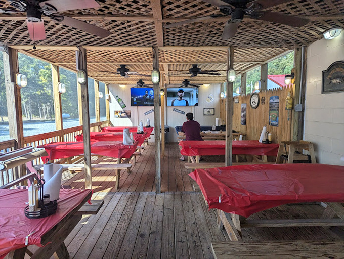 The covered deck at Linton's isn't just a dining area – it's a community table where strangers become friends over shared crab mallets.
