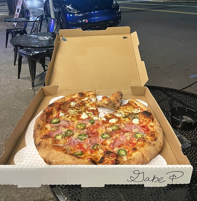 Pizza to-go that somehow maintains its dignity in transit—note the perfect char on that crust even in takeout form.