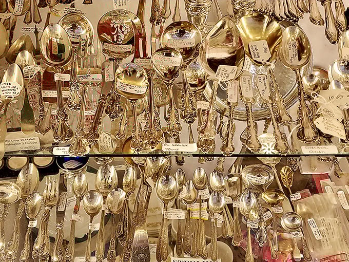Silver utensils hanging like precious metallic fruit. Each spoon and fork has scooped up history one bite at a time.