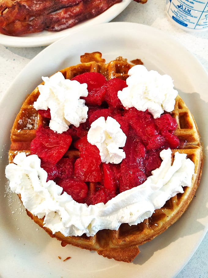 A waffle that's dressed for success with strawberries and whipped cream—breakfast that thinks it's dessert, and we're not complaining.