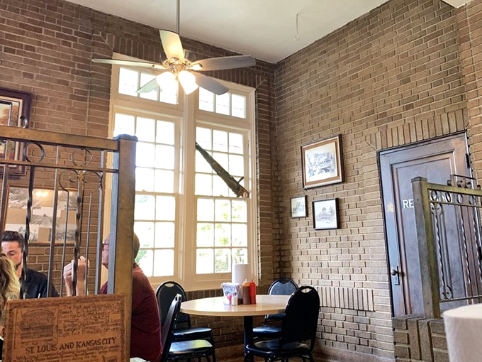 Tall windows flood the brick-walled dining area with natural light, creating the perfect backdrop for serious barbecue contemplation.