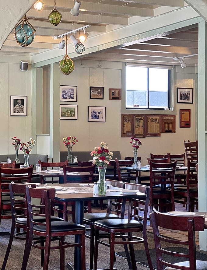 Colorful glass floats and black-and-white photos create a maritime museum vibe. Each table gets its own fresh flower centerpiece—a small but meaningful touch.
